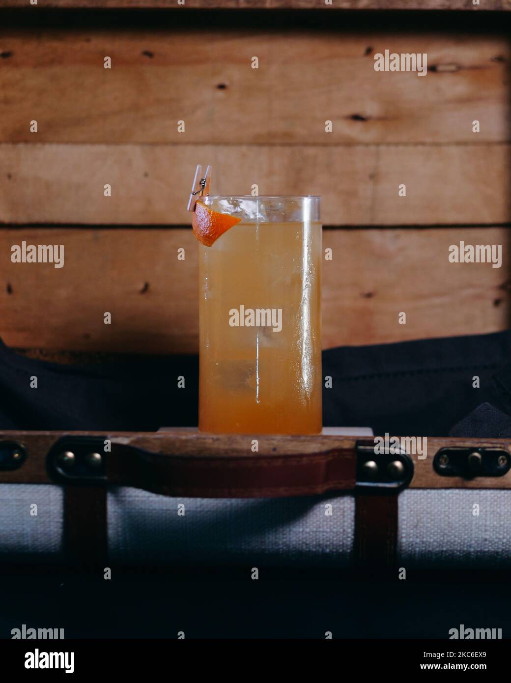 A vertical shot of a delicious orange cocktail inside a chest in a bar ...