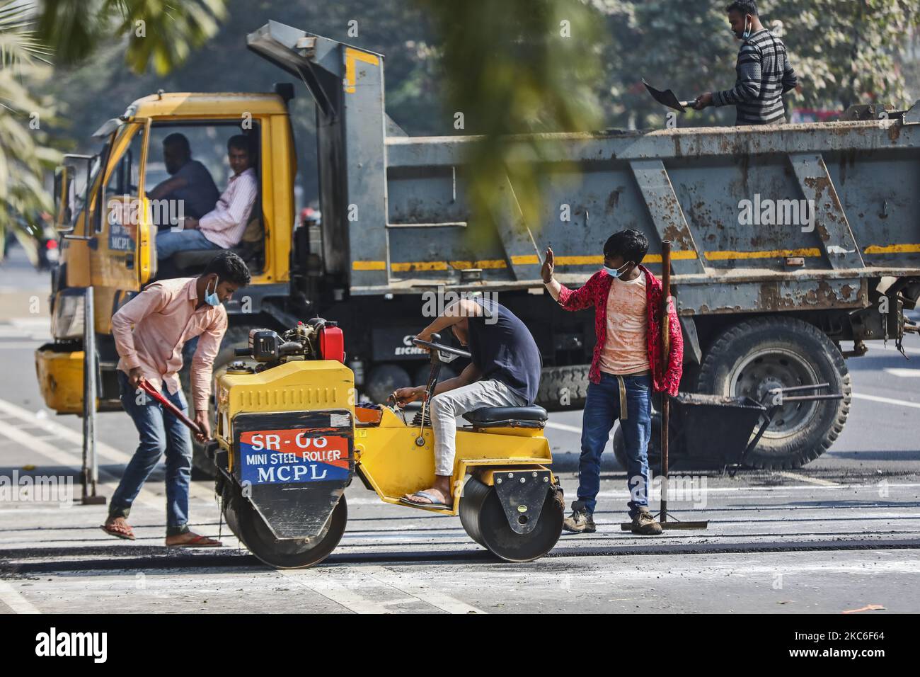 Construction workers installing a speed breaker in Dhaka, Bangladesh on ...