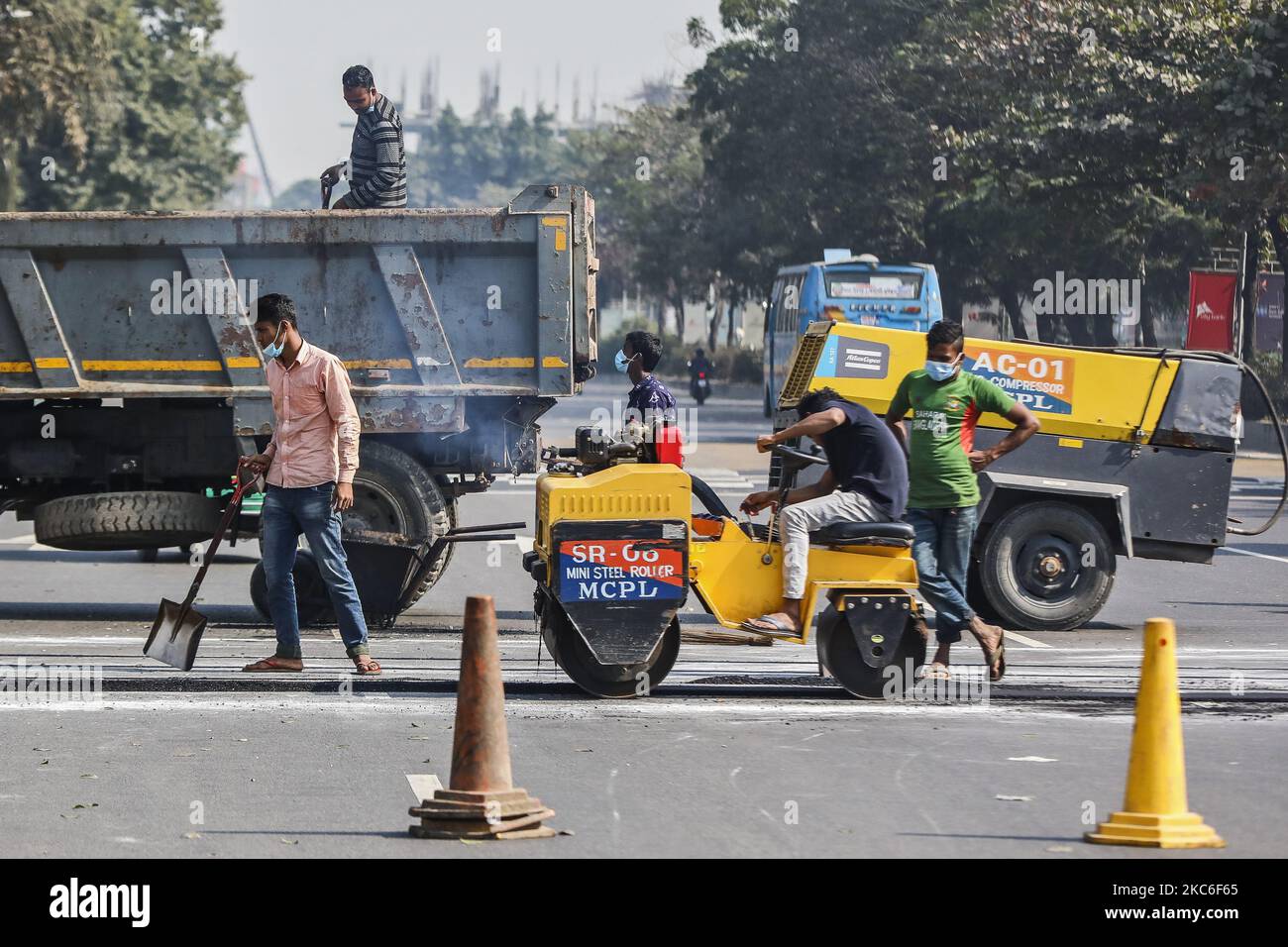 Construction workers installing a speed breaker in Dhaka, Bangladesh on ...
