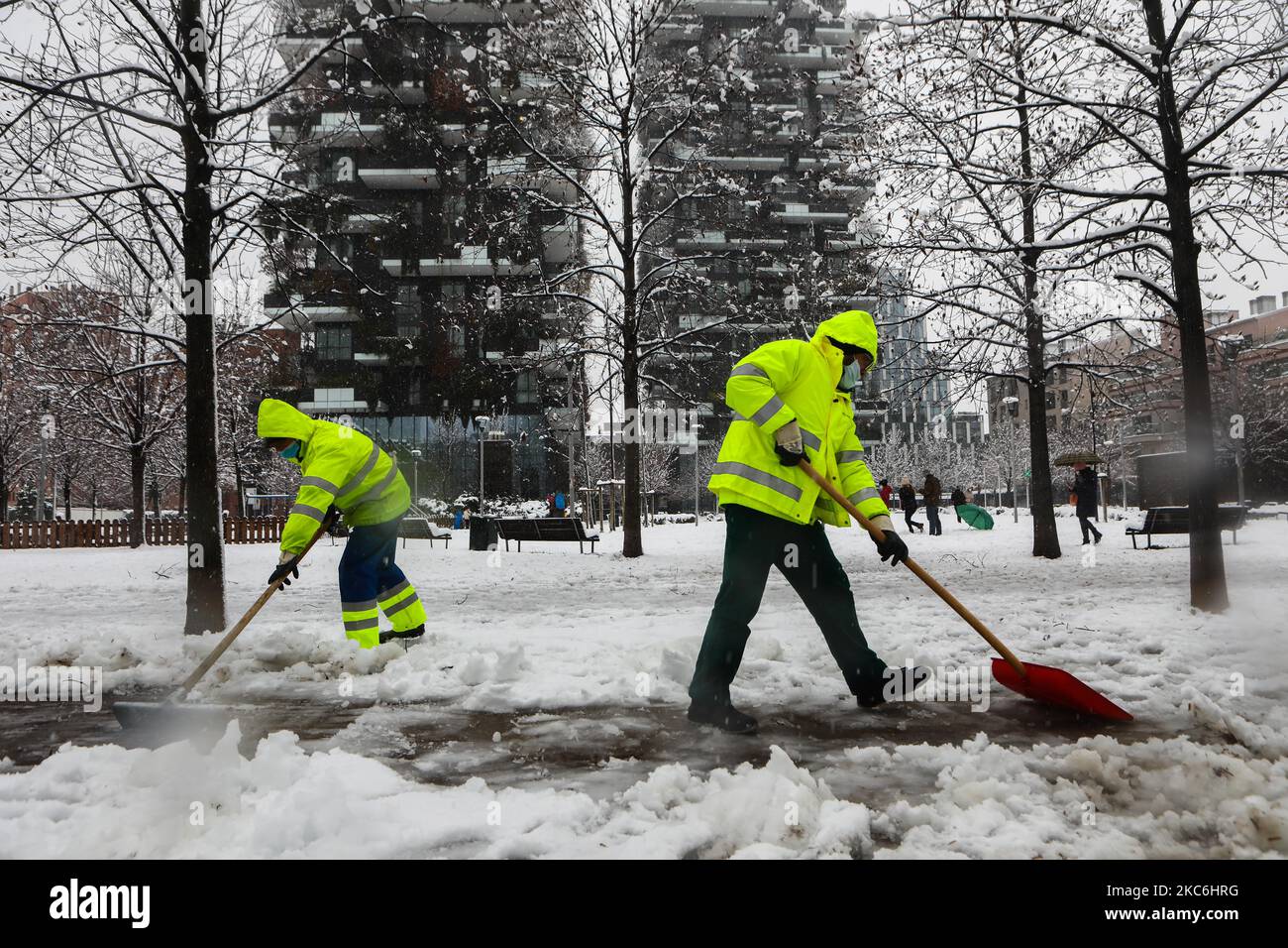 Two men snowplow in action at Bosco Verticale (Vertical Forest) during ...