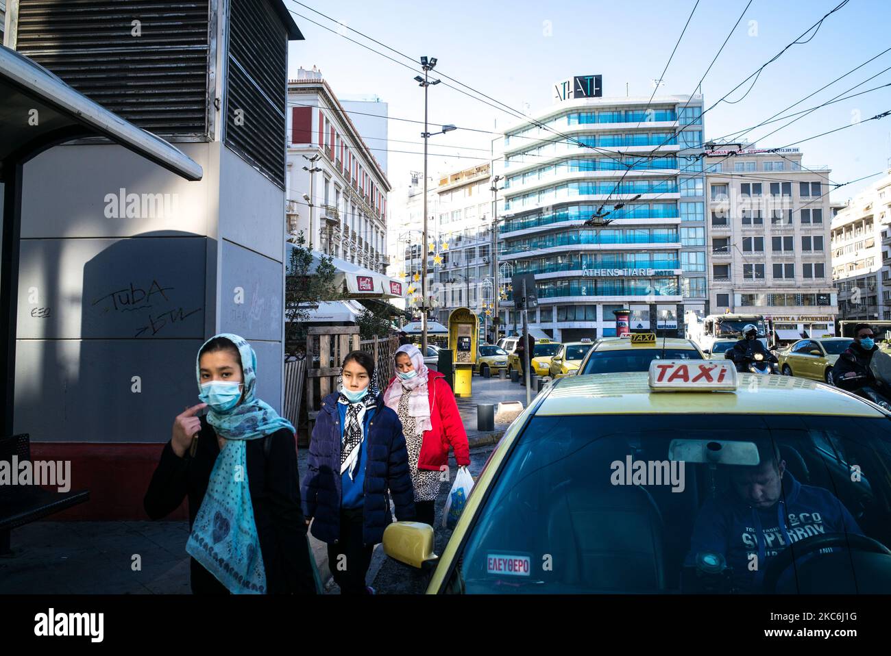 Three girls walking while wearing their masks in Omonoia square in downtown Athens on December ...
