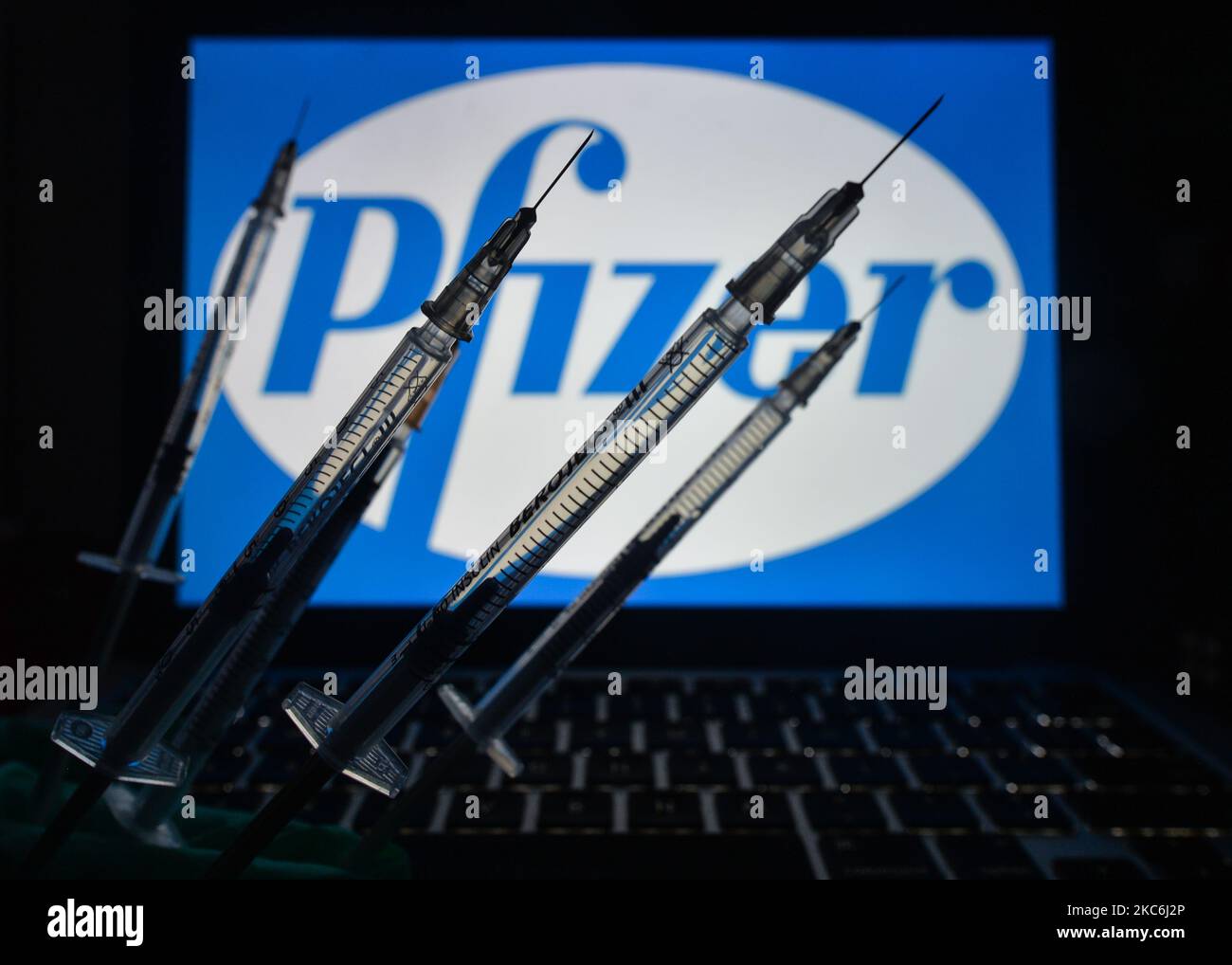 An illustrative image of medical syringes seen in front of Pfizer logo ...