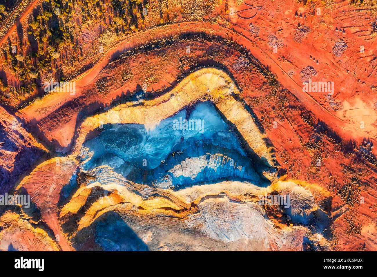 Colourful top down aerial view over open pit mine in Cobar copper town ...
