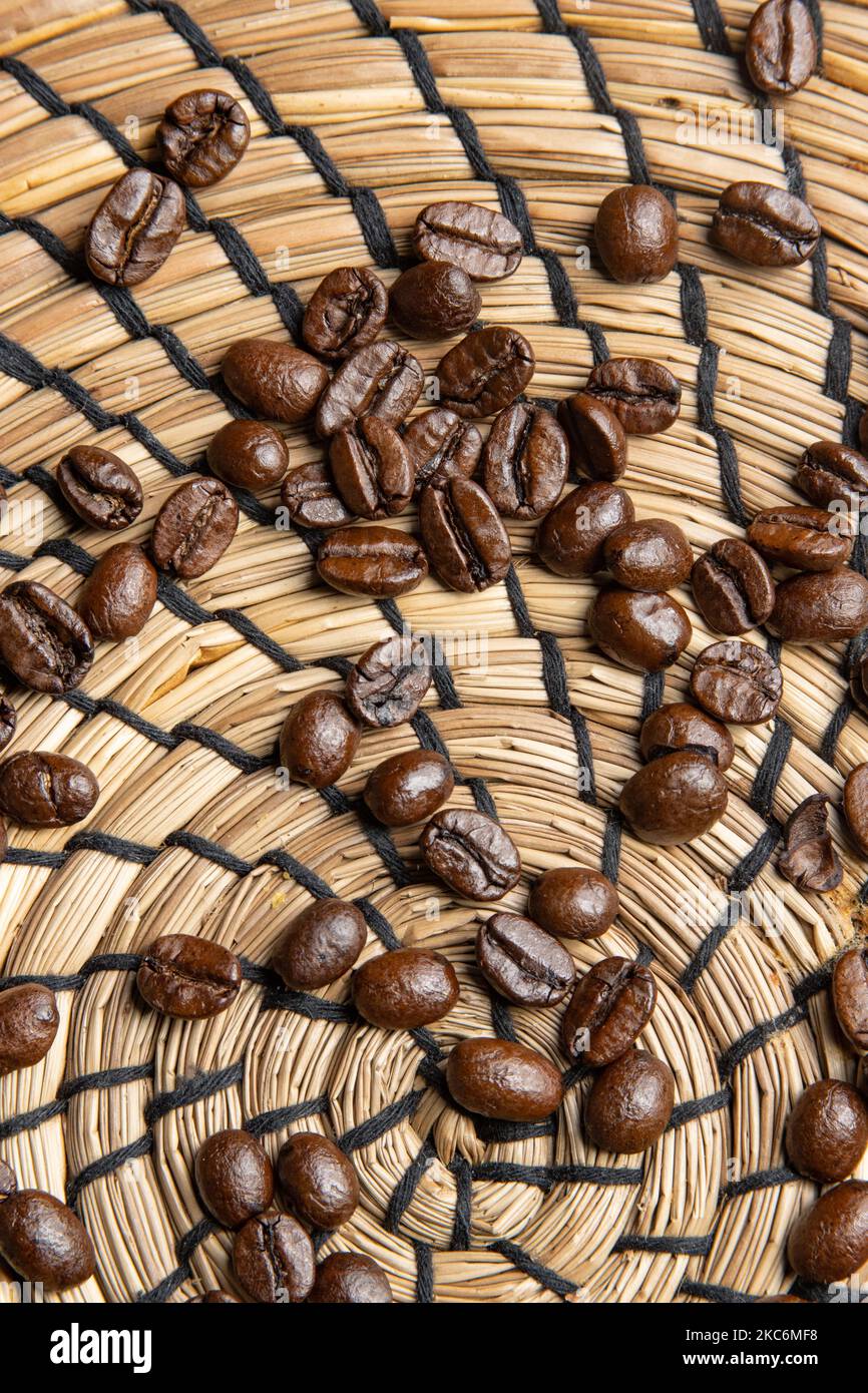 Raw organic Arabica variety coffee beans on a straw background isolated ...