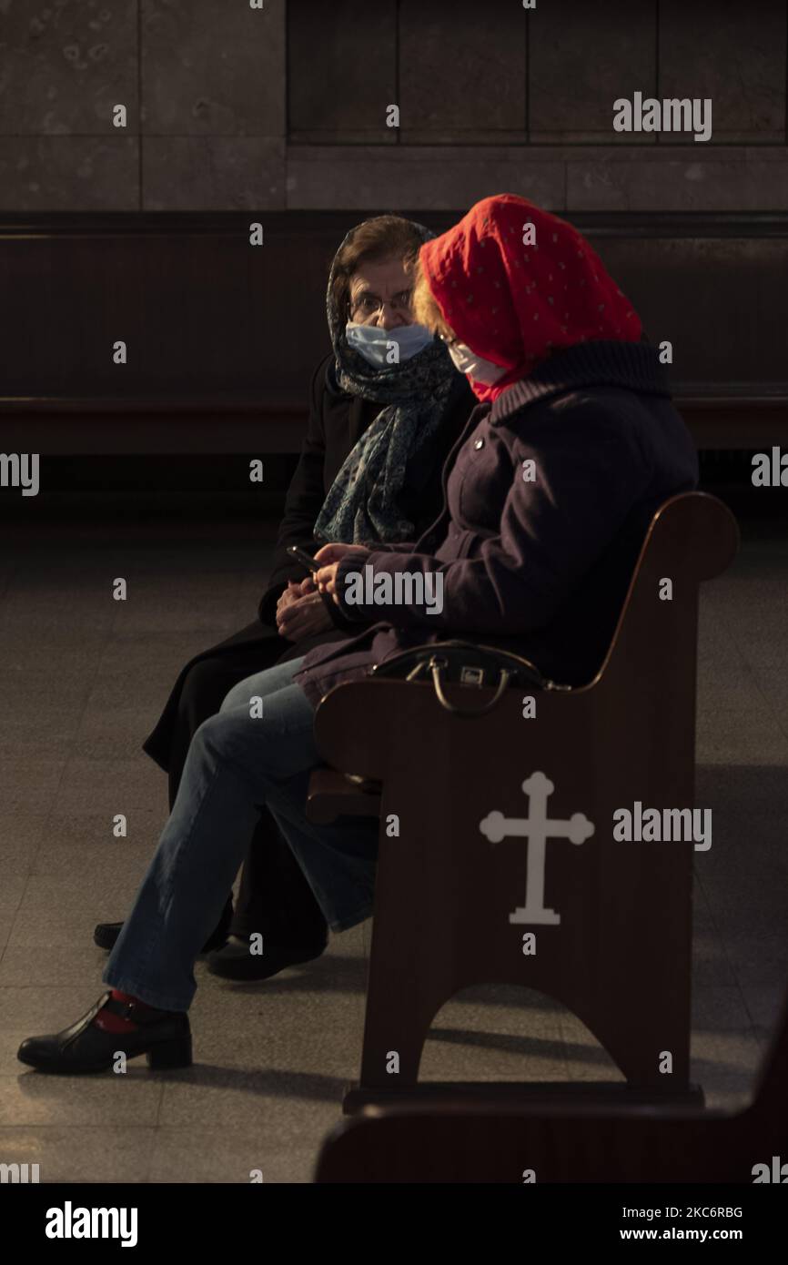 Two Iranian-Christian women wearing protective face masks talk to each ...