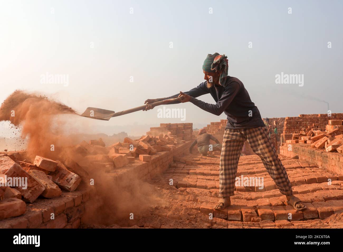 A brickfield worker is working in brickfields at Narayanganj near Dhaka ...