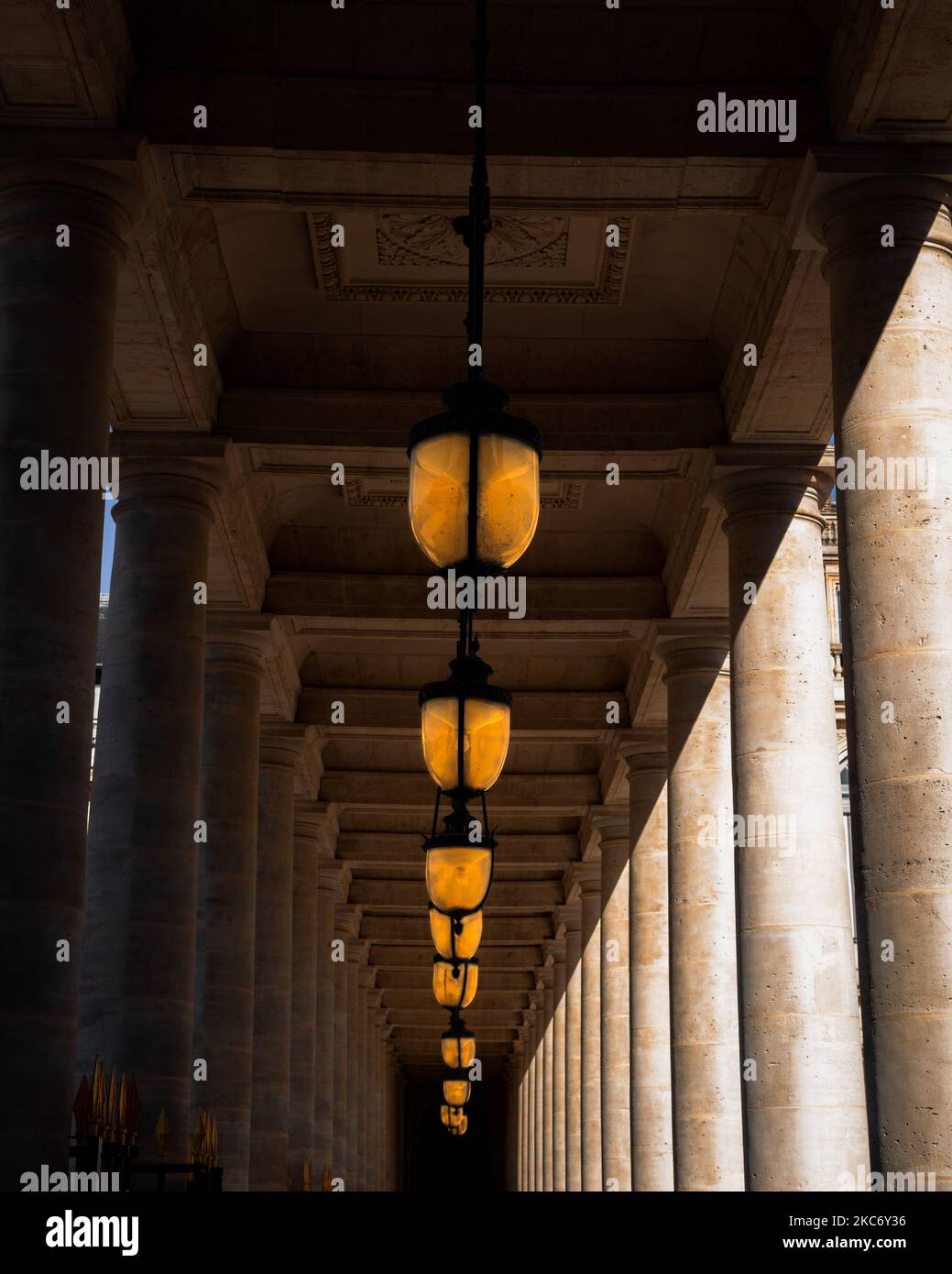 A series of ceiling hanging lamps in a corridor old building with ...