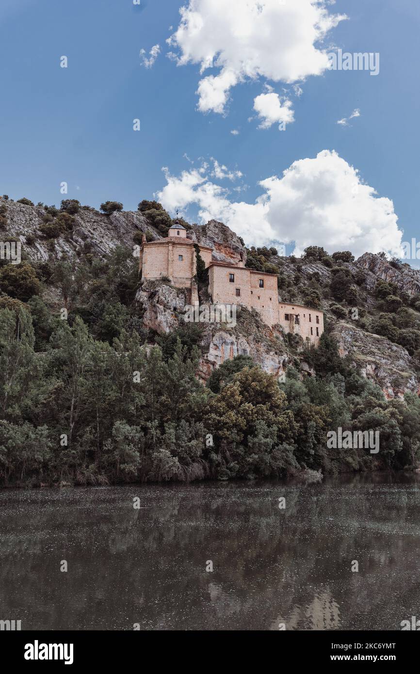 A vertical shot of the Hermitage of San Saturio hillside chapel with a ...