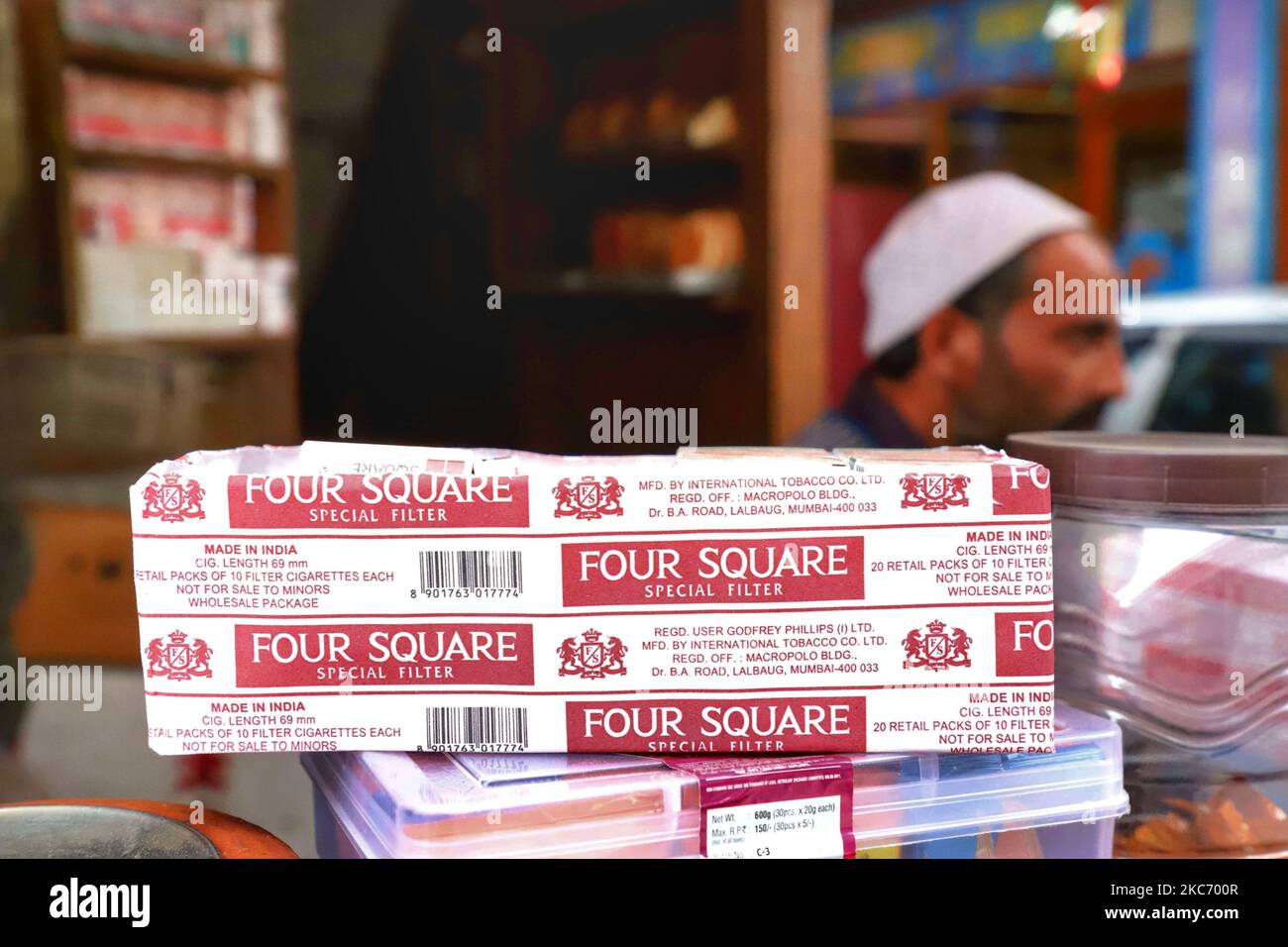 A shopkeeper selling Four Square Cigarettes waits for the customers at ...