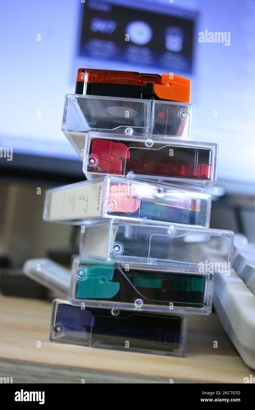 A vertical closeup shot of colorful plastic DV tapes stacked on top of ...