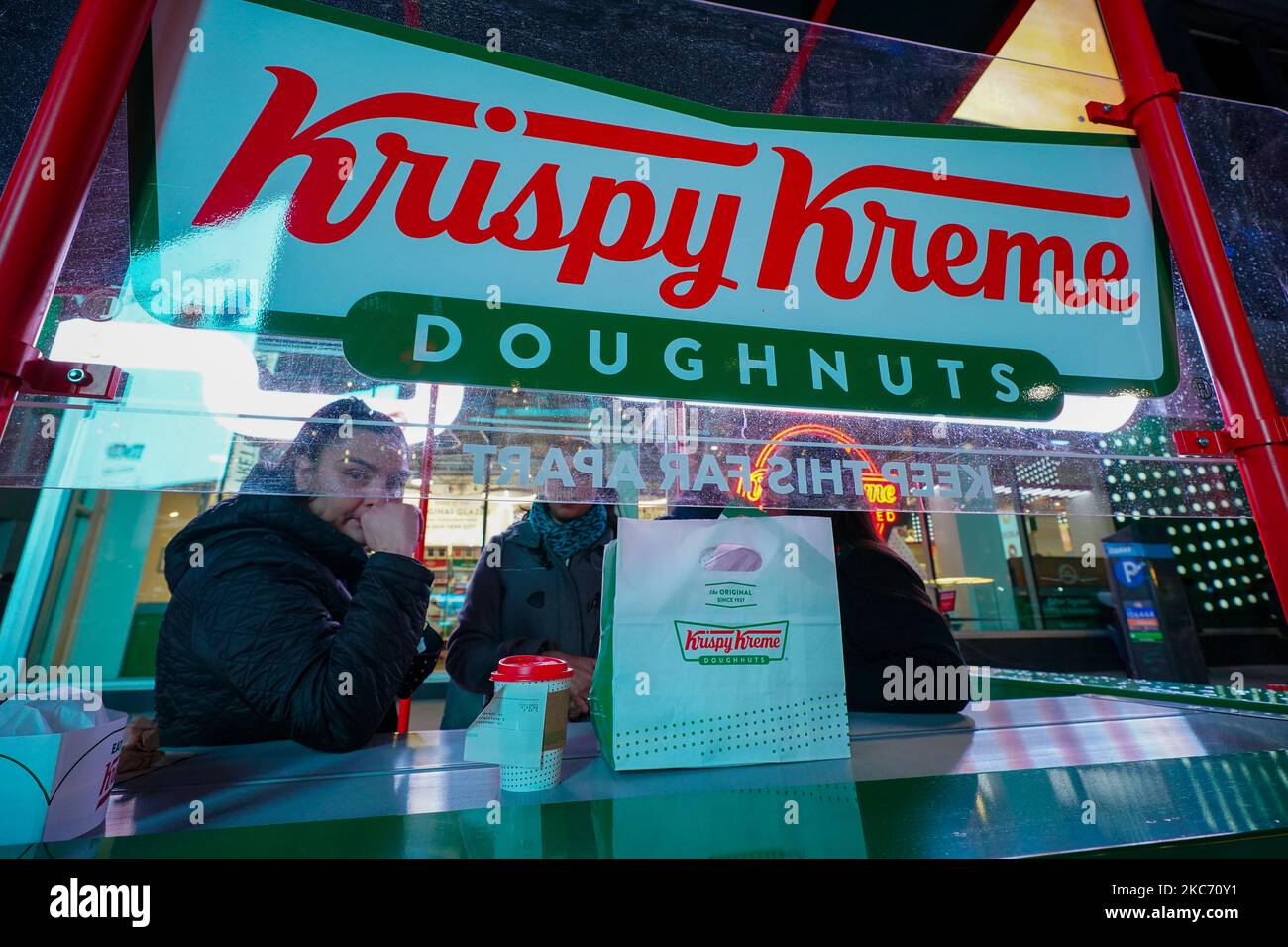 A view of people at an outdoor dining set up of Krispy Kreme in their ...