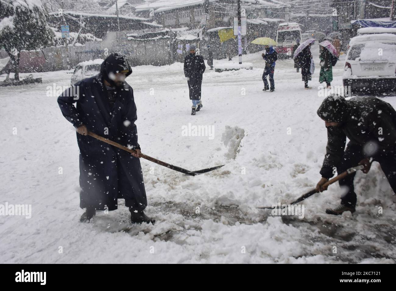 People clear the roads amid heavy snowfall as snowfall contimues for ...