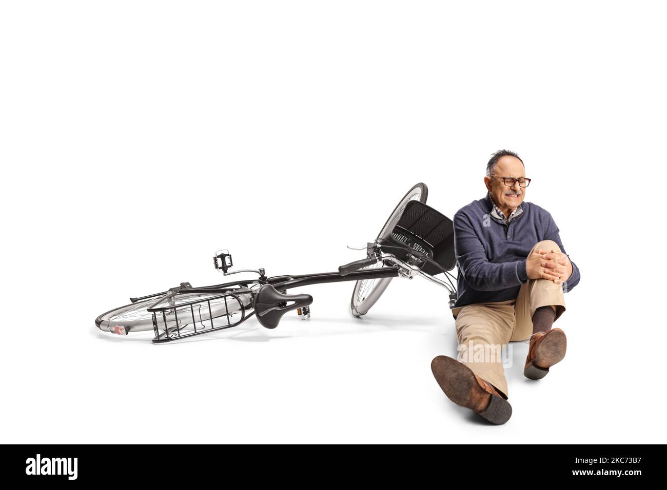 Mature man falling off a bicycle and hurting his knee isolated on white ...