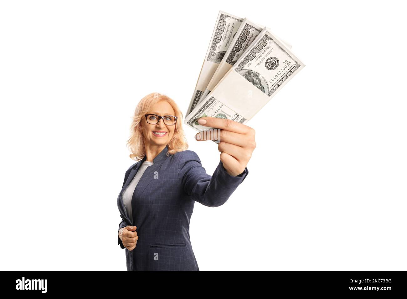 Mature woman holding stacks of money and smiling isolated on white ...