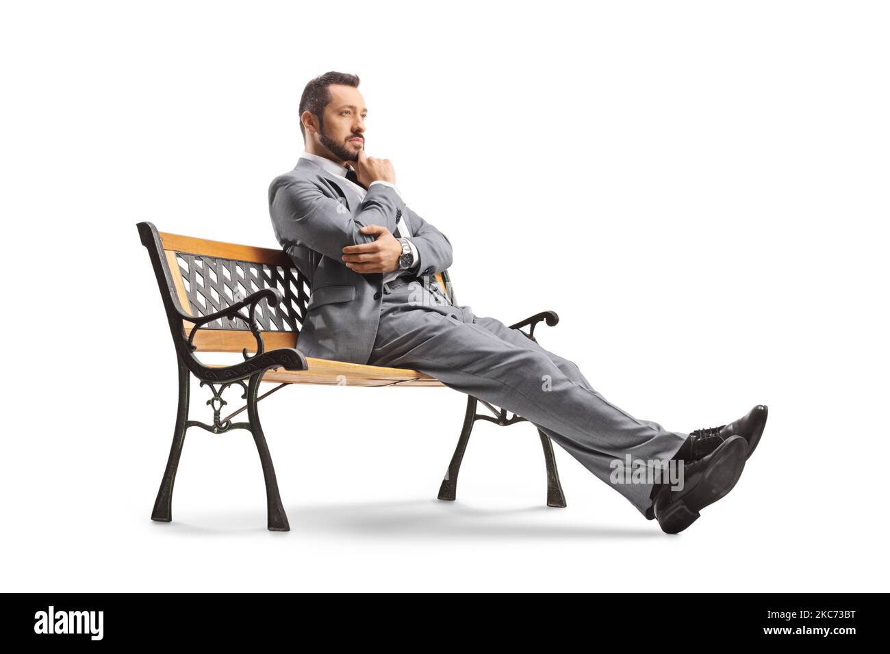 Pensive businessman sitting on a bench isolated on white background ...