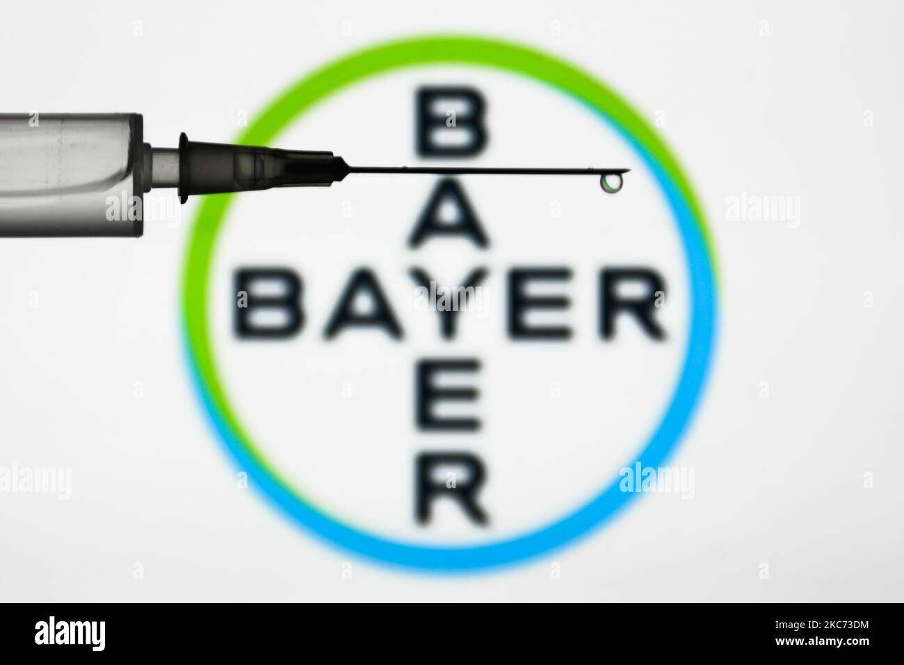 Medical syringe is seen with Bayer logo displayed in the background in ...