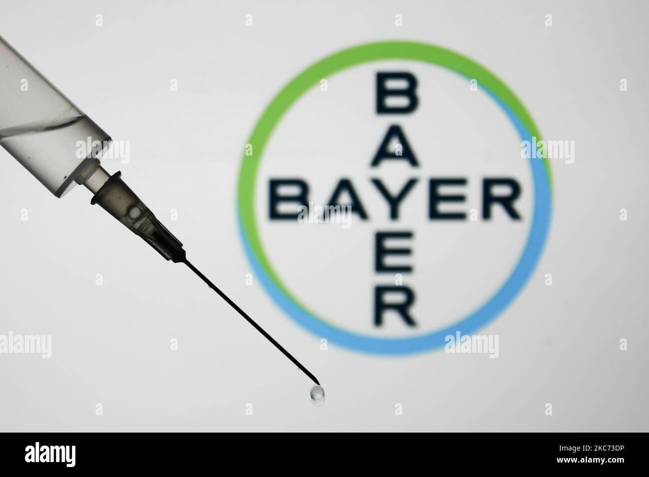 Medical syringe is seen with Bayer logo displayed in the background in ...