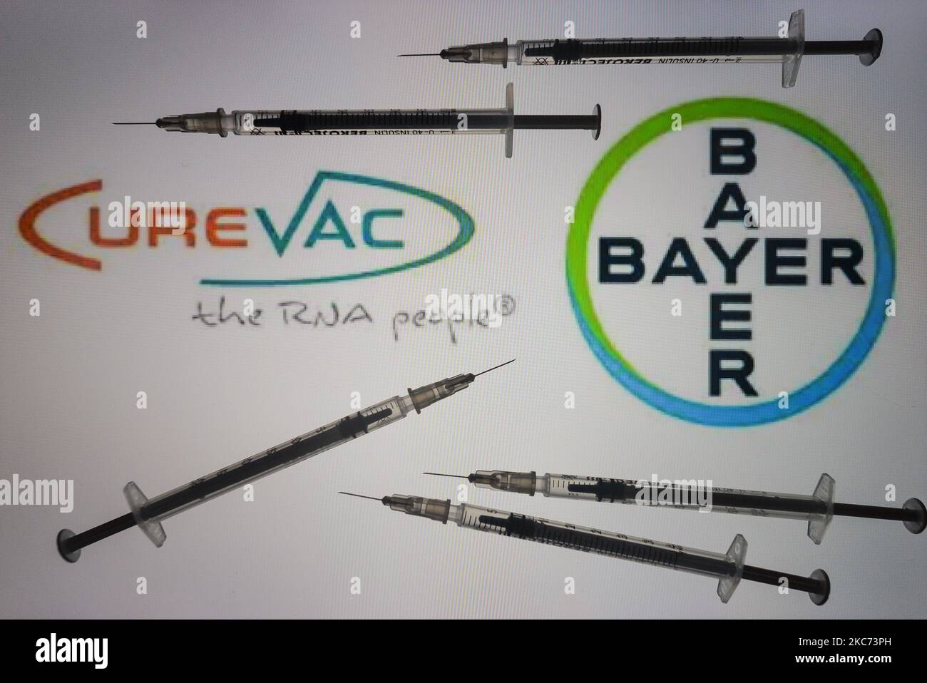 An illustrative image of medical syringes in front of CureVac and Bayer ...