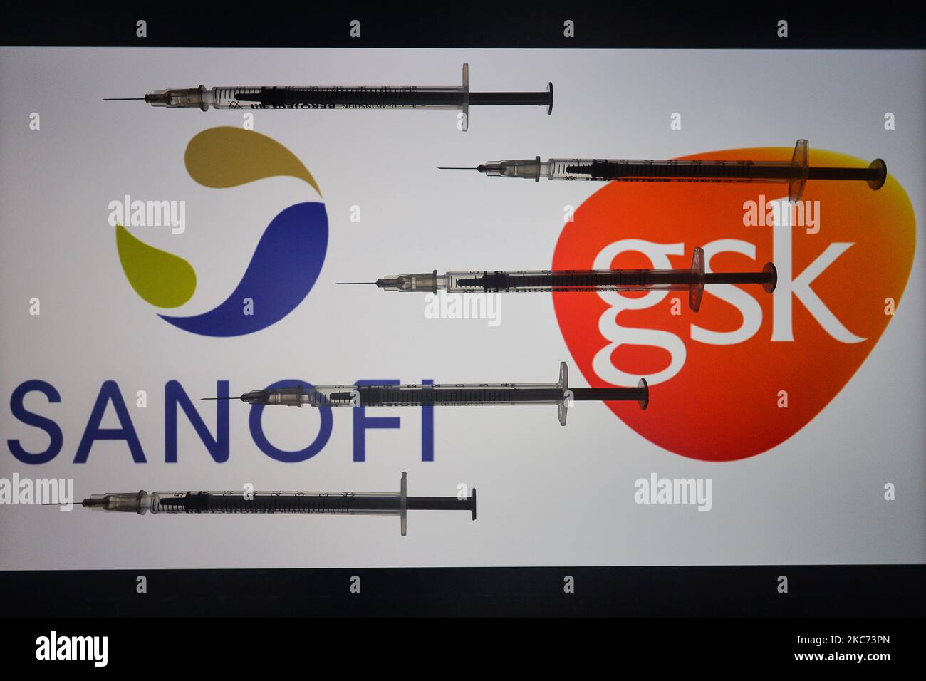 An illustrative image of medical syringes in front of GSK-Sanofi logo ...