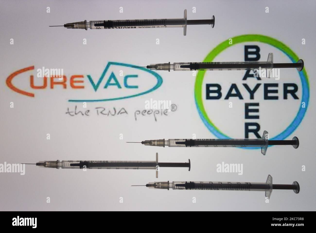 An illustrative image of medical syringes in front of Bayer and CureVac ...