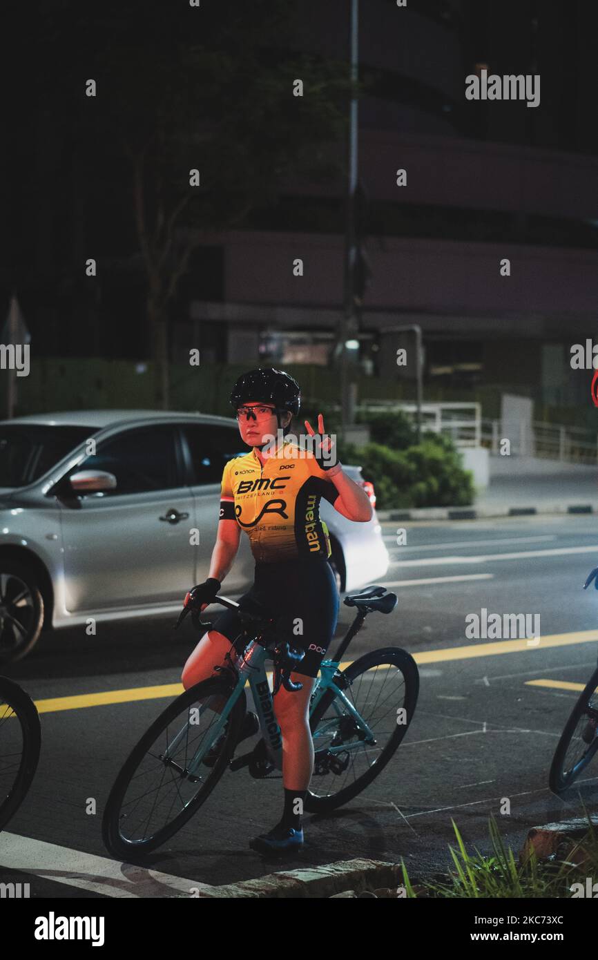An Asian cyclist with uniform riding on asphalt road and showing ...