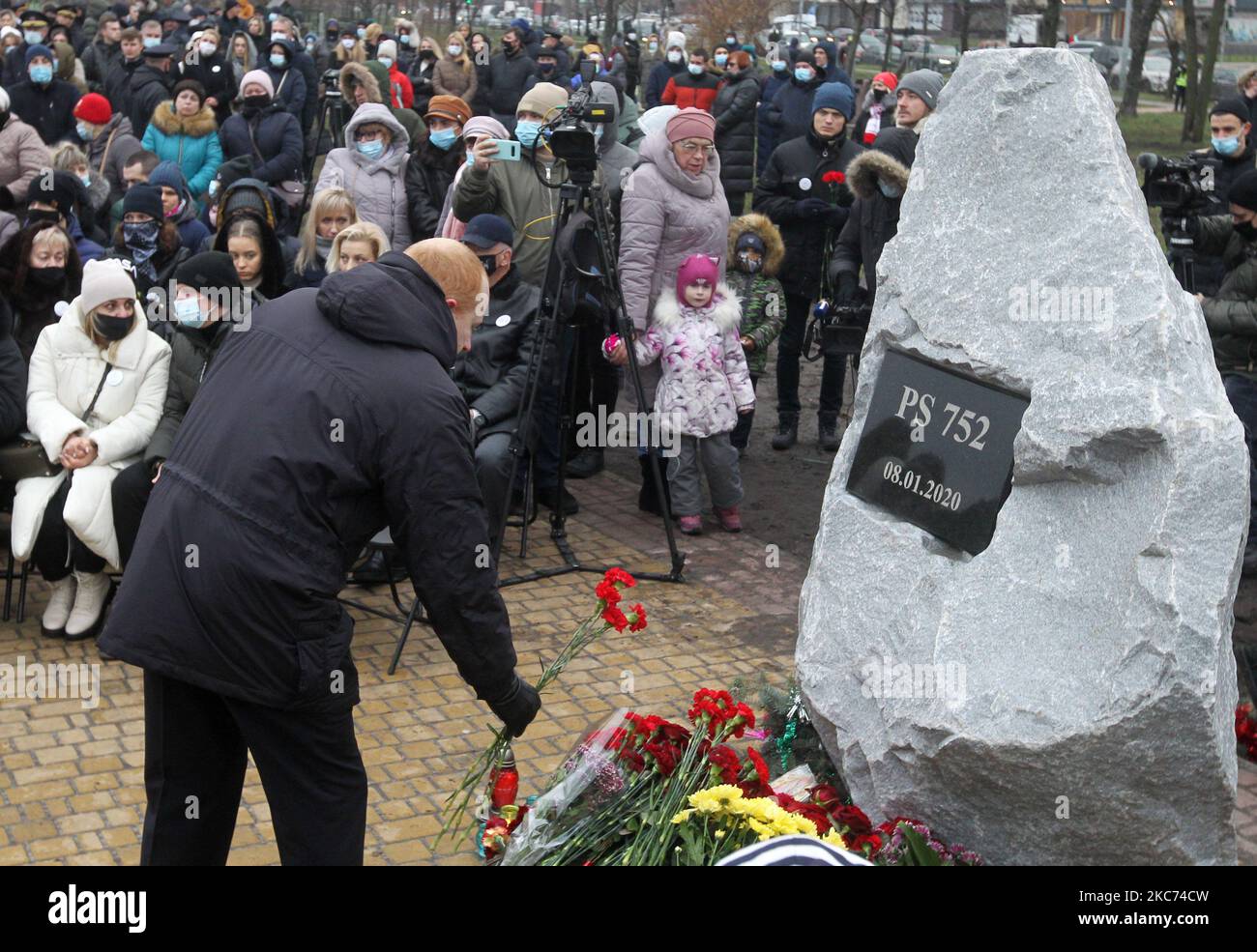 A man lays flowers during an honoring ceremony in the memory of victims ...