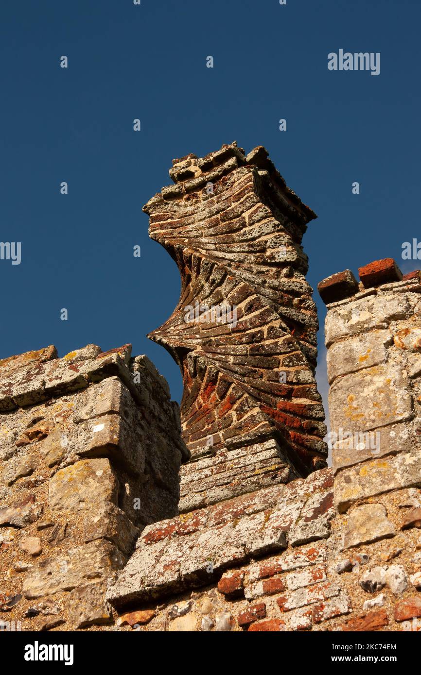 An Ancient weathered ornate damaged chimney stack against blue sky ...