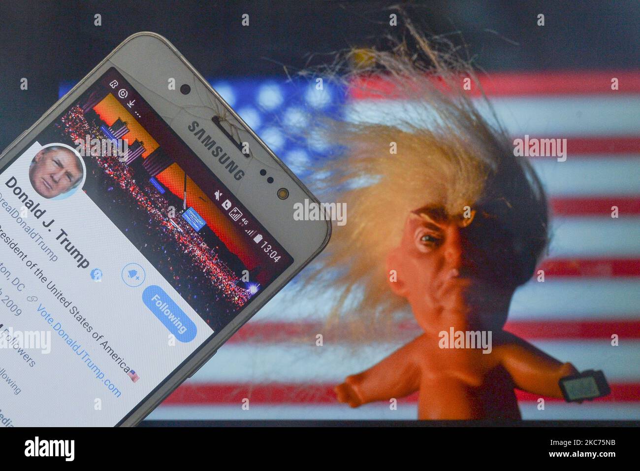Donald Trump's Twitter account displayed on a mobile phone screen next ...