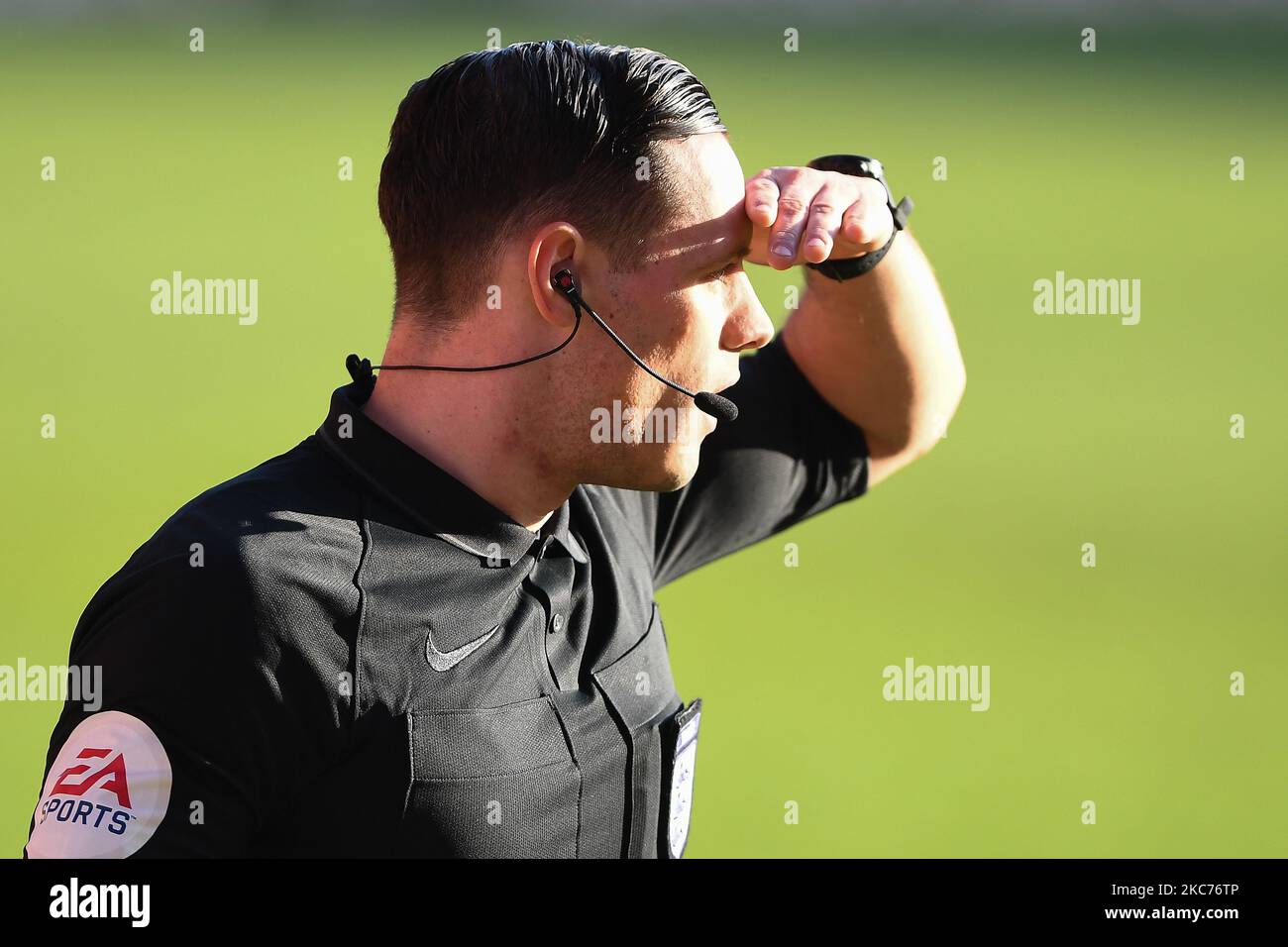 Assistant referee shields his eyes from the low sun during the FA Cup ...
