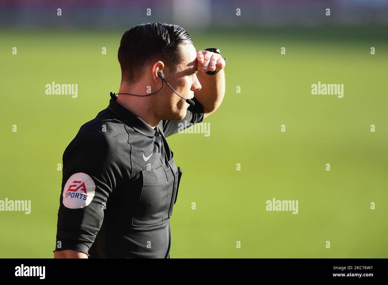 Assistant referee shields his eyes from the low sun during the FA Cup ...