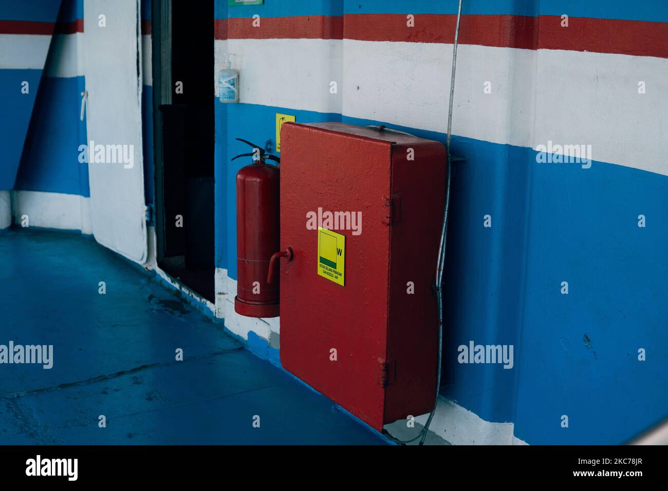 A red box and a fire extinguisher on a ferry ship Stock Photo - Alamy
