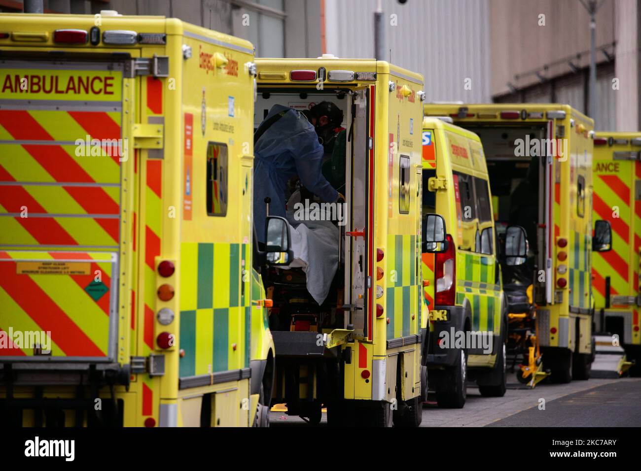 A medic wearing PPE treats a patient wearing an oxygen mask inside an ...