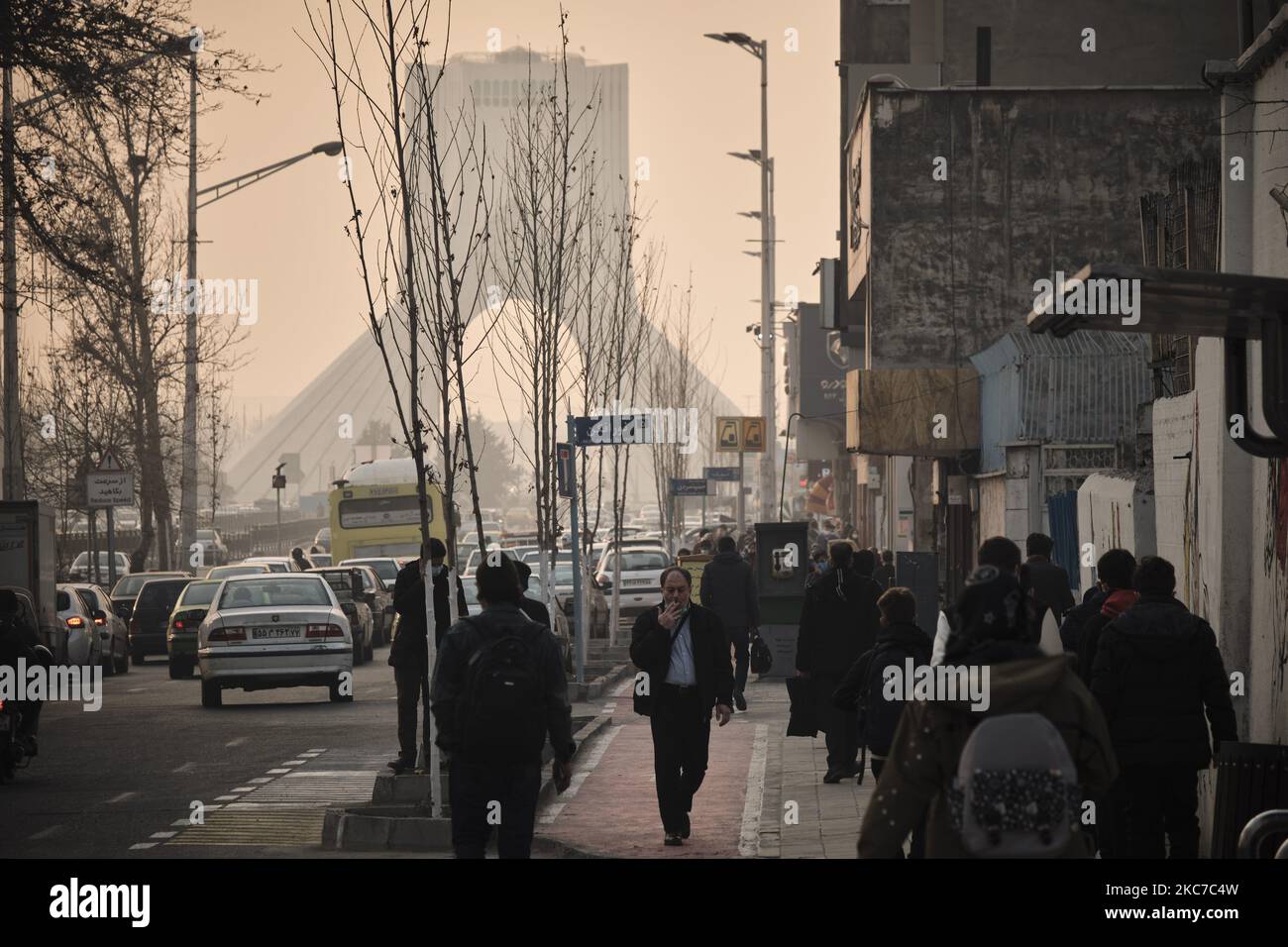Iranian people walk along a street-side in western Tehran during a ...