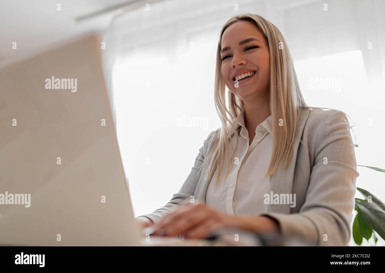 Business woman in office working on lap top Stock Photo - Alamy