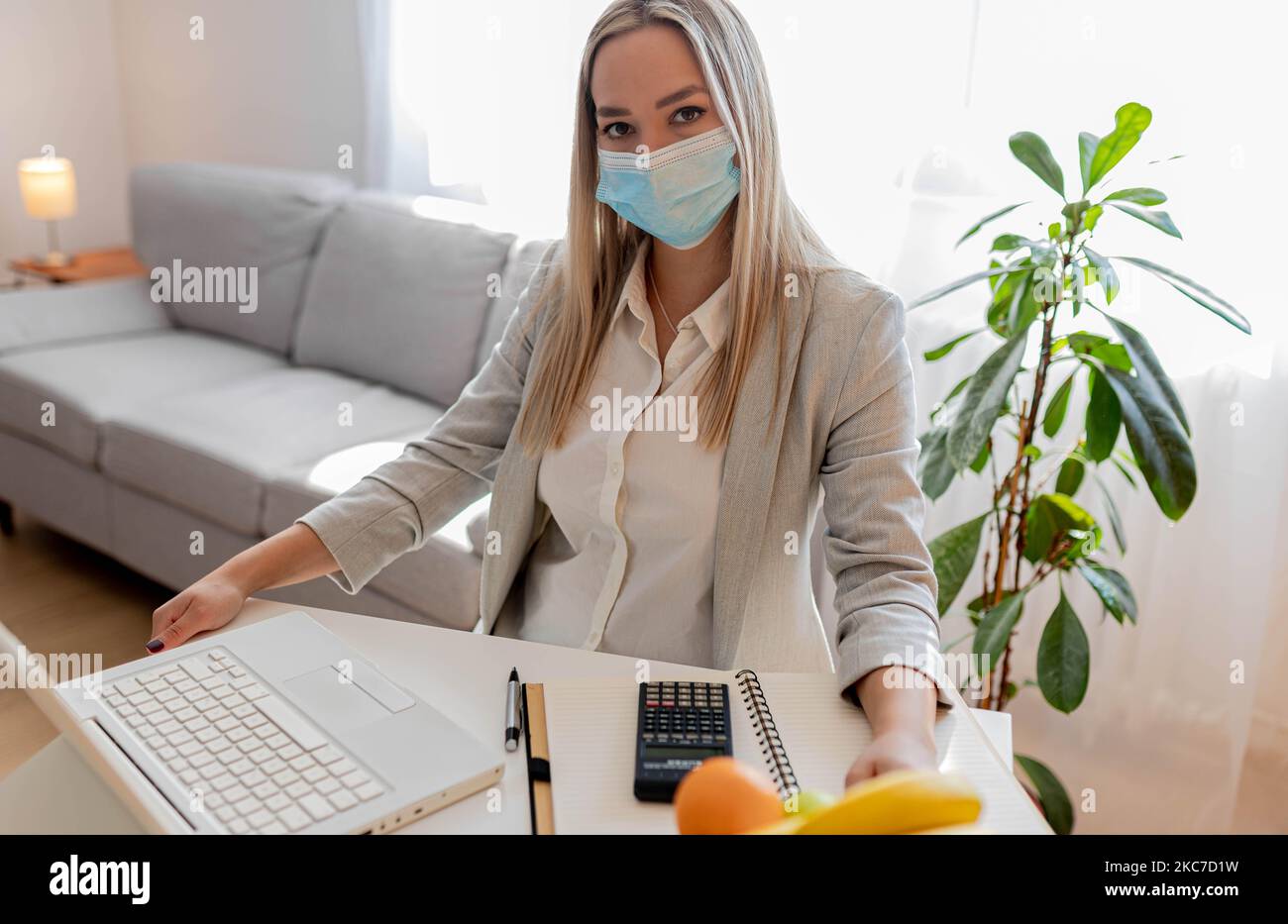 Female employee wearing medical face mask while working in the business ...