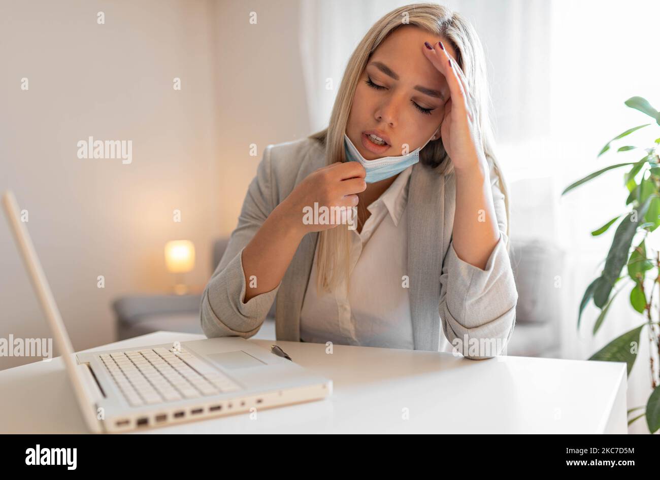 Woman working in the office and having difficulties breathing with face ...