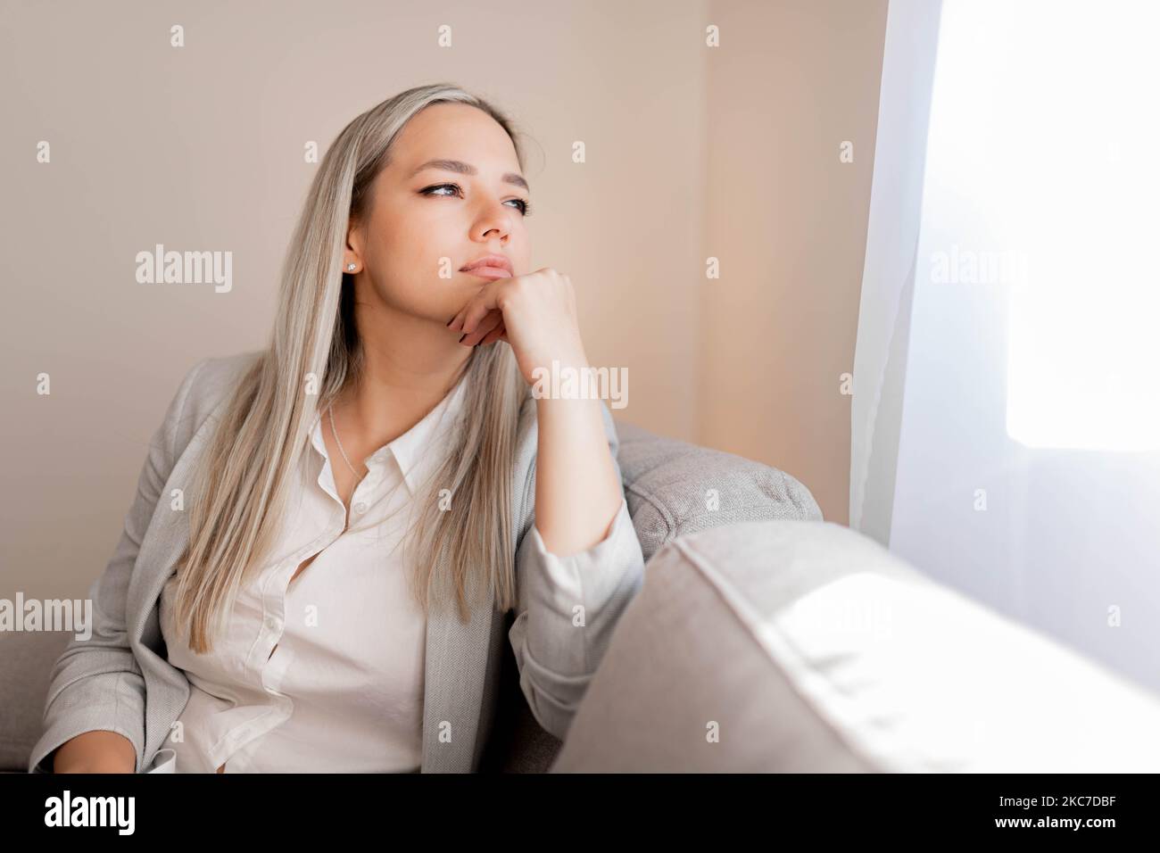 Sad and depressed woman sitting on sofa and looking at distance. Woman ...