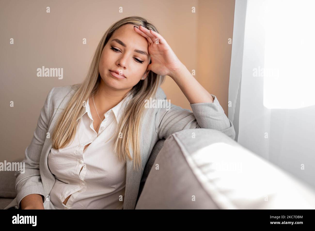 Sad and depressed woman sitting on sofa and looking at distance. Woman ...