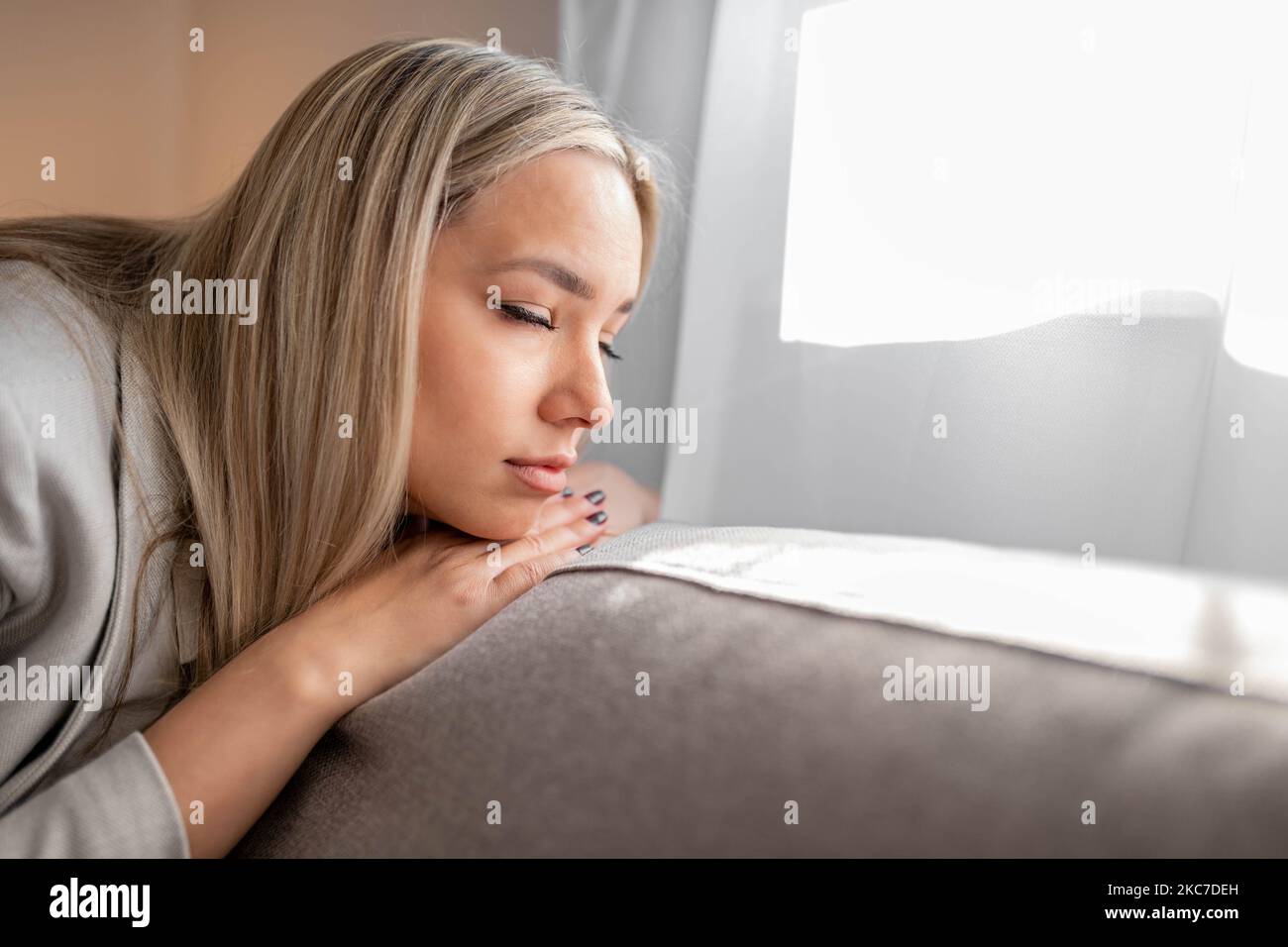 Sad and depressed woman sitting on sofa and looking at distance. Woman ...