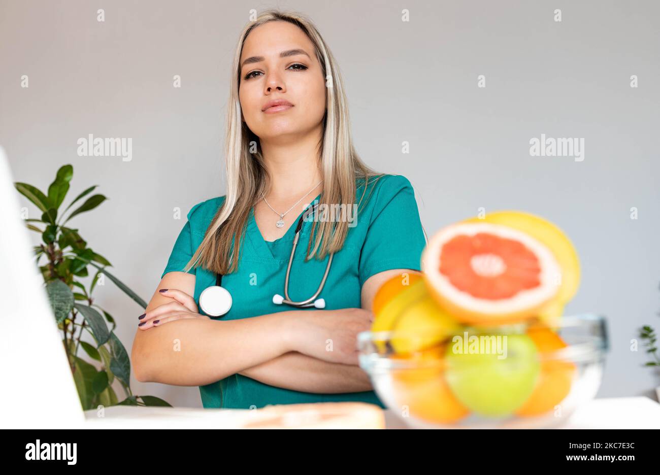 Female nutritionist with fruits working at her desk. Smiling ...