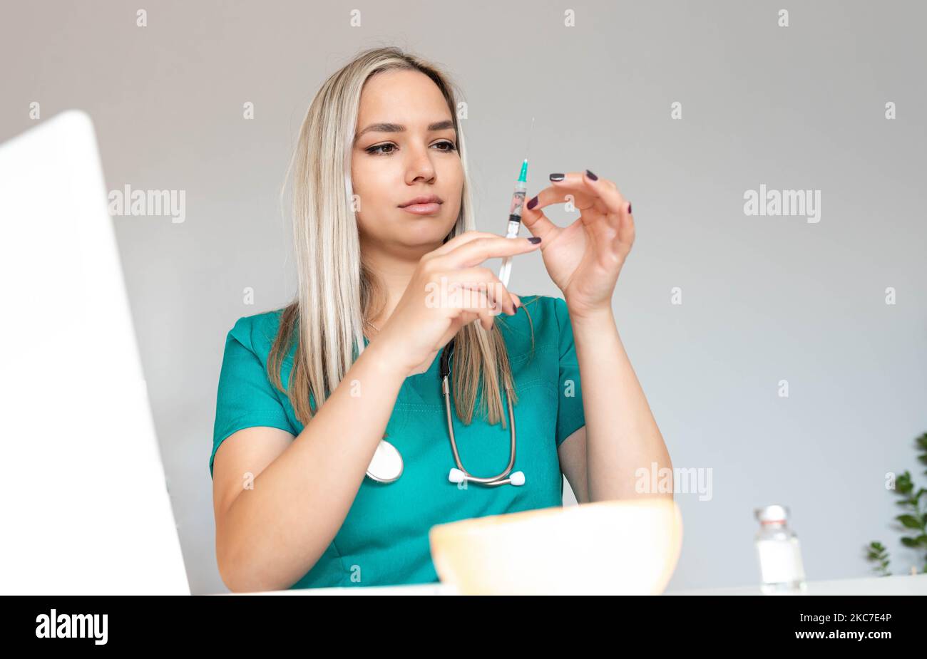 Female doctor or nurse holding syringe with injection and medicine ...
