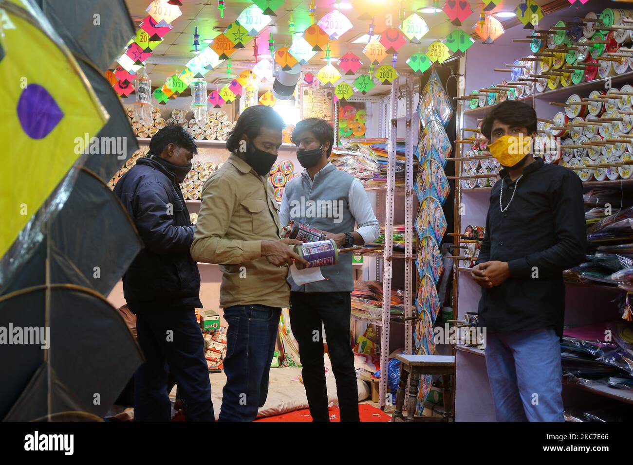 People buy kites at a shop ahead of the Makar Sankranti festival at ...