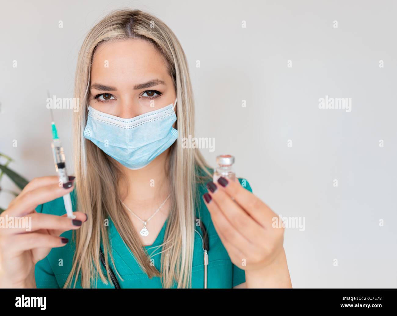 Female doctor or nurse holding syringe with injection and medicine ...