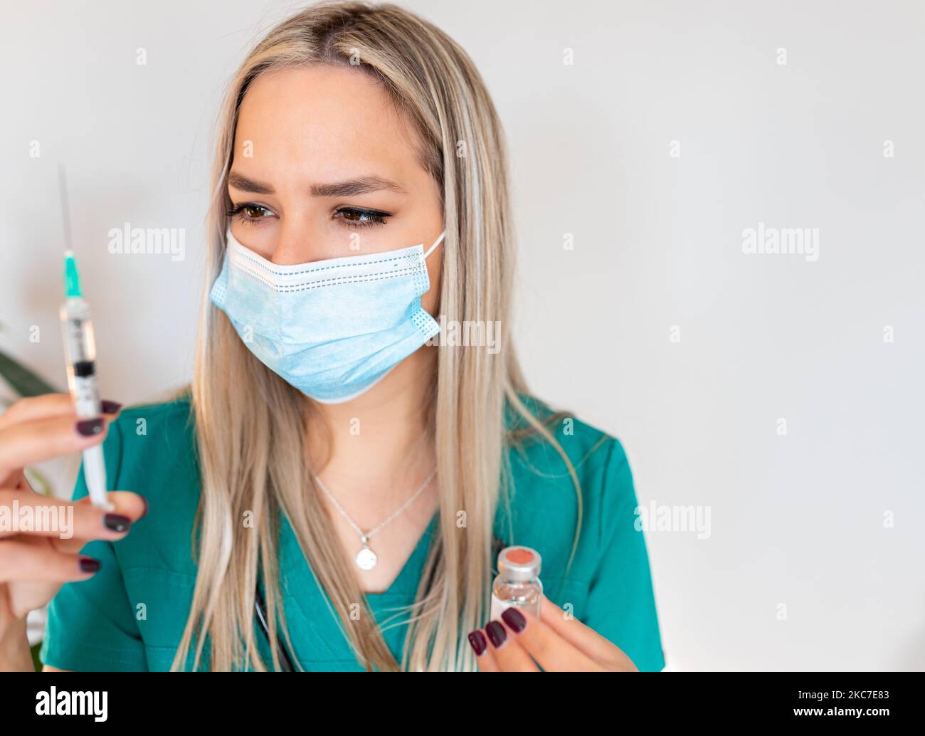 Female doctor or nurse holding syringe with injection and medicine ...