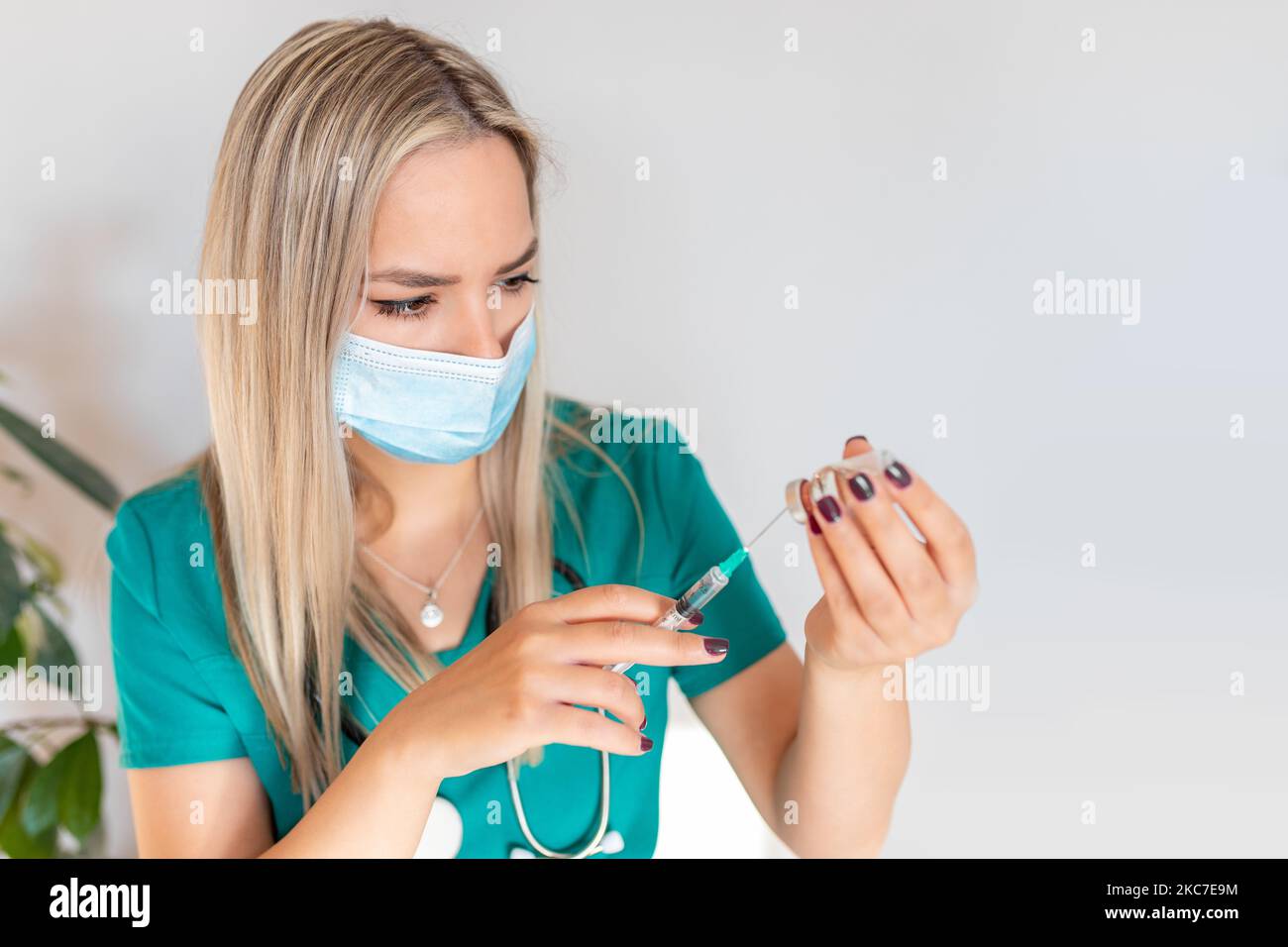 Female doctor or nurse holding syringe with injection and medicine ...