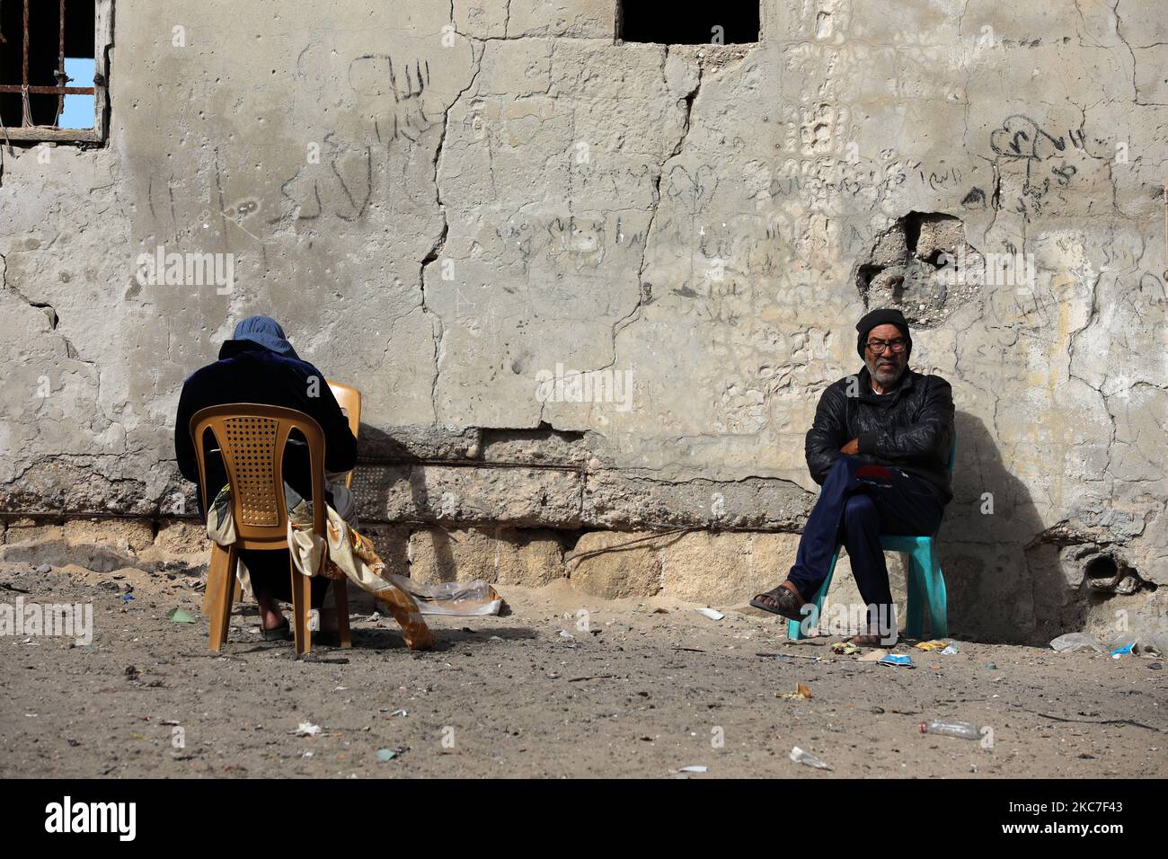 Palestinian refugees sit outside their home in the al-Shati refugee ...