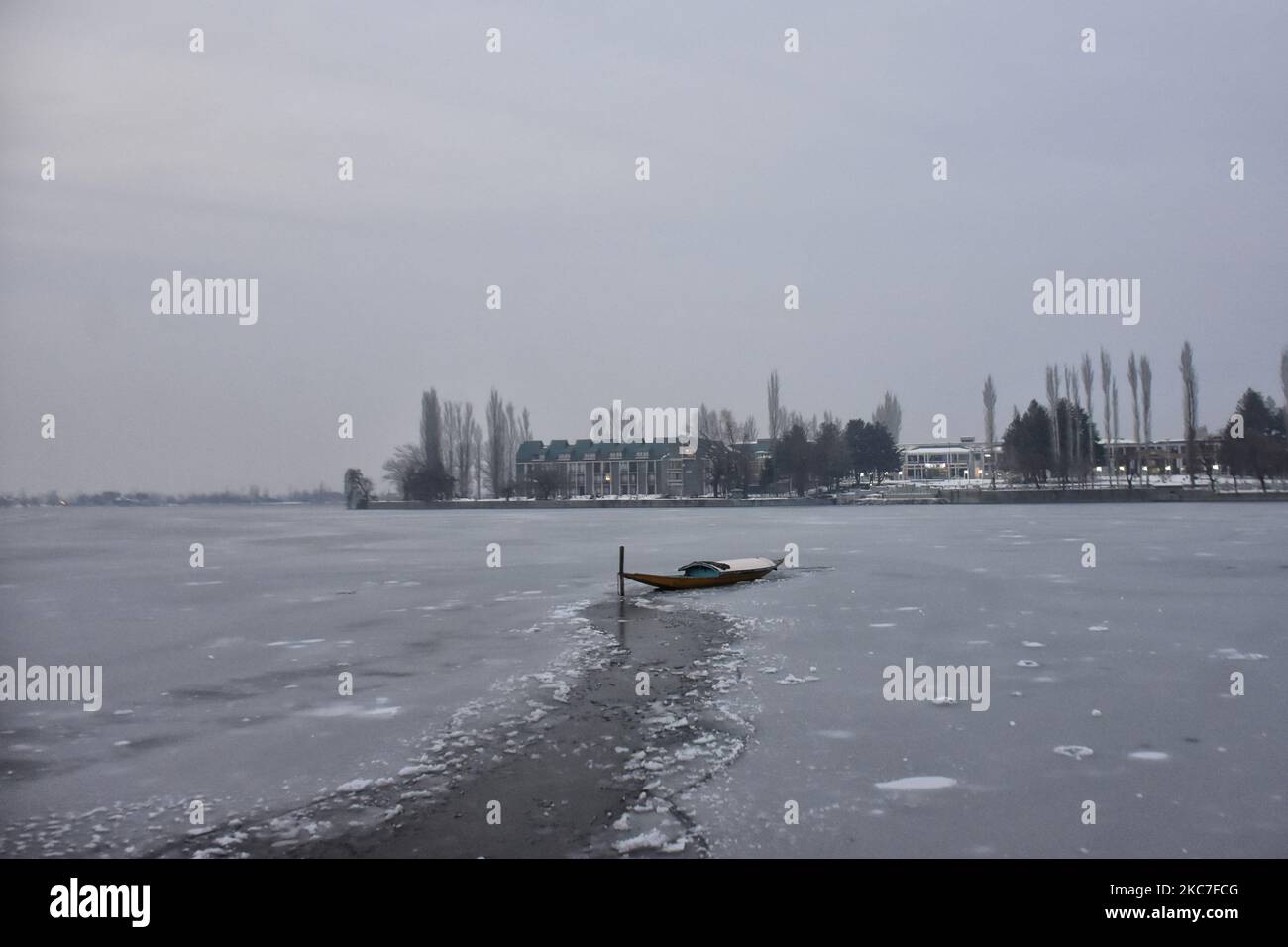 A stranded shikara remains stuck in ice inside t frozen Dal Lake ...