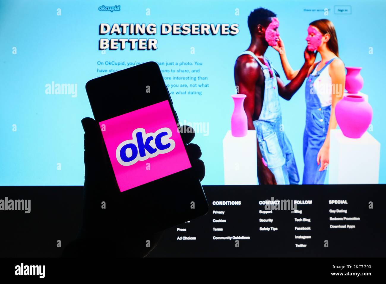 OkCupid app logo is displayed on a mobile phone screen photographed on ...