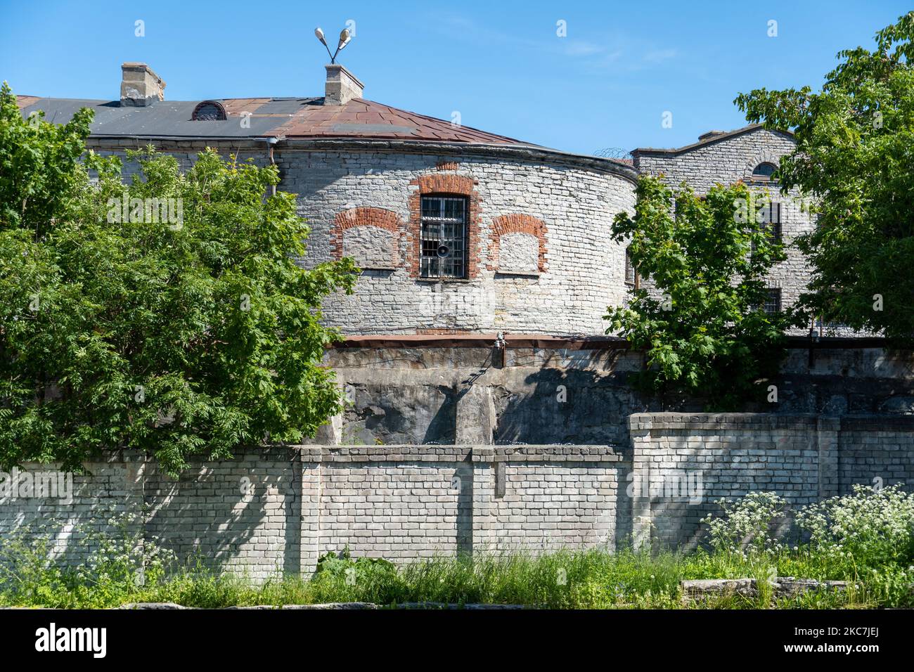 A brick building of the Patarei Prison surrounded by the trees in ...