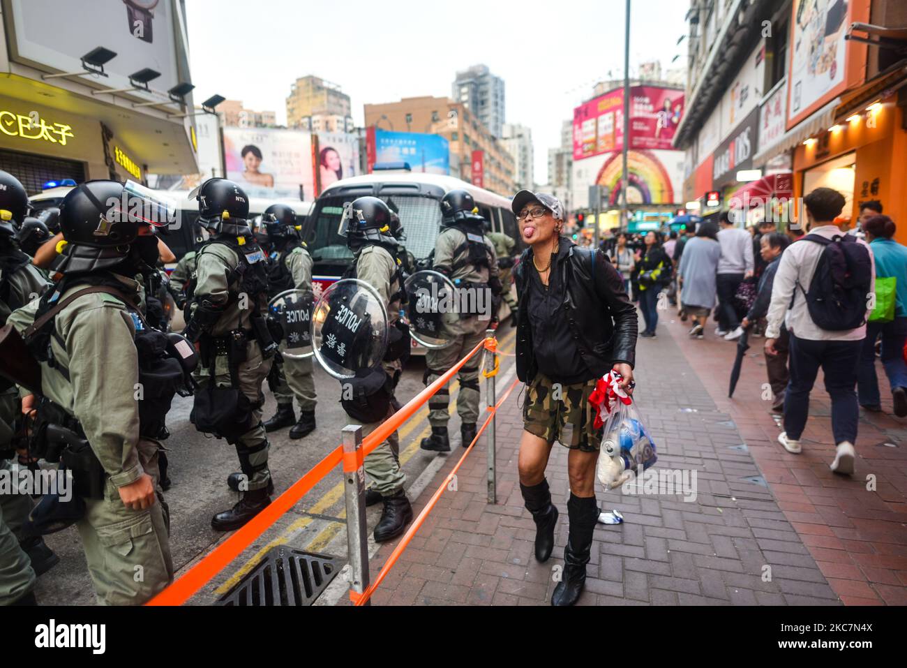 A Filipina, with several empty cans of beer shows her tongue to riot ...